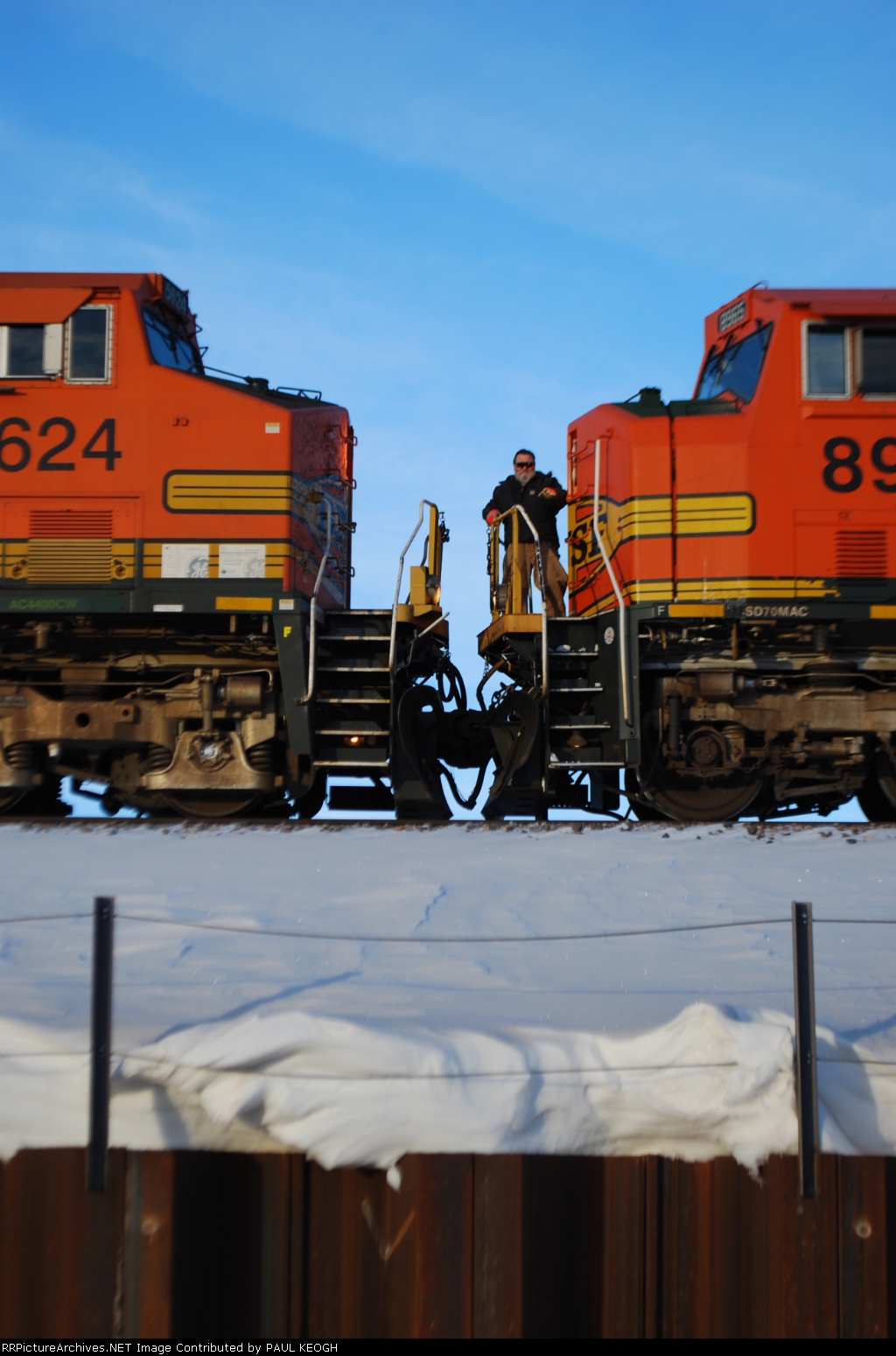 BNSF 8965's Brakeman crosses over to the left side of BNSF 8965 to open the airline just behind ...